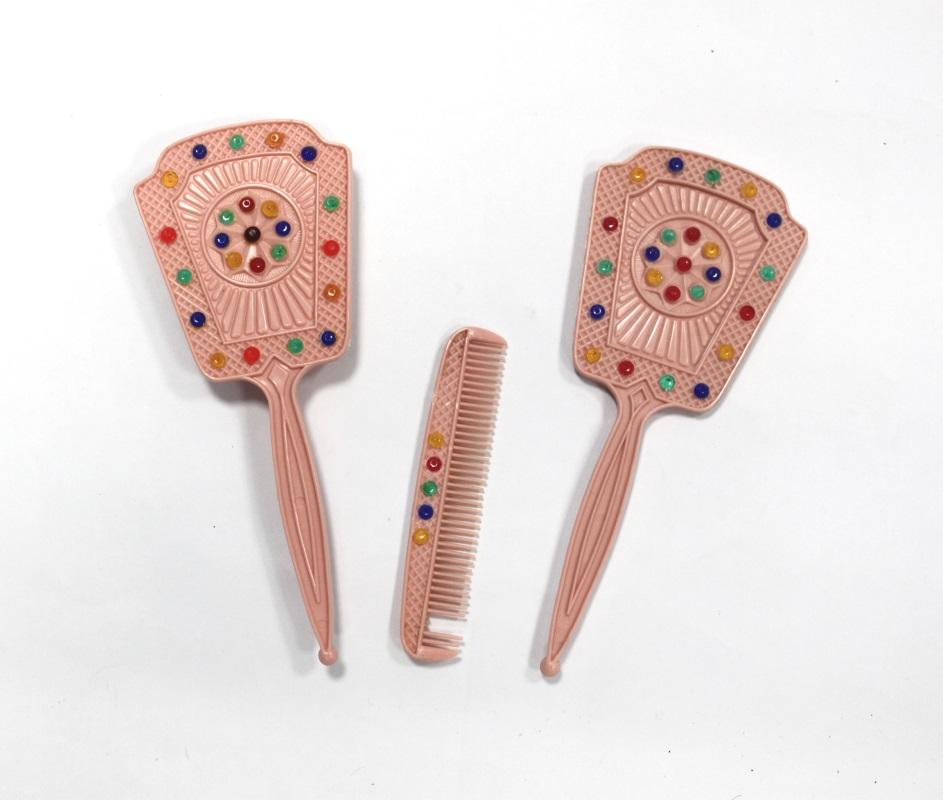 Toy comb c.late 1950s in pink plastic with coloured gems on the front ...